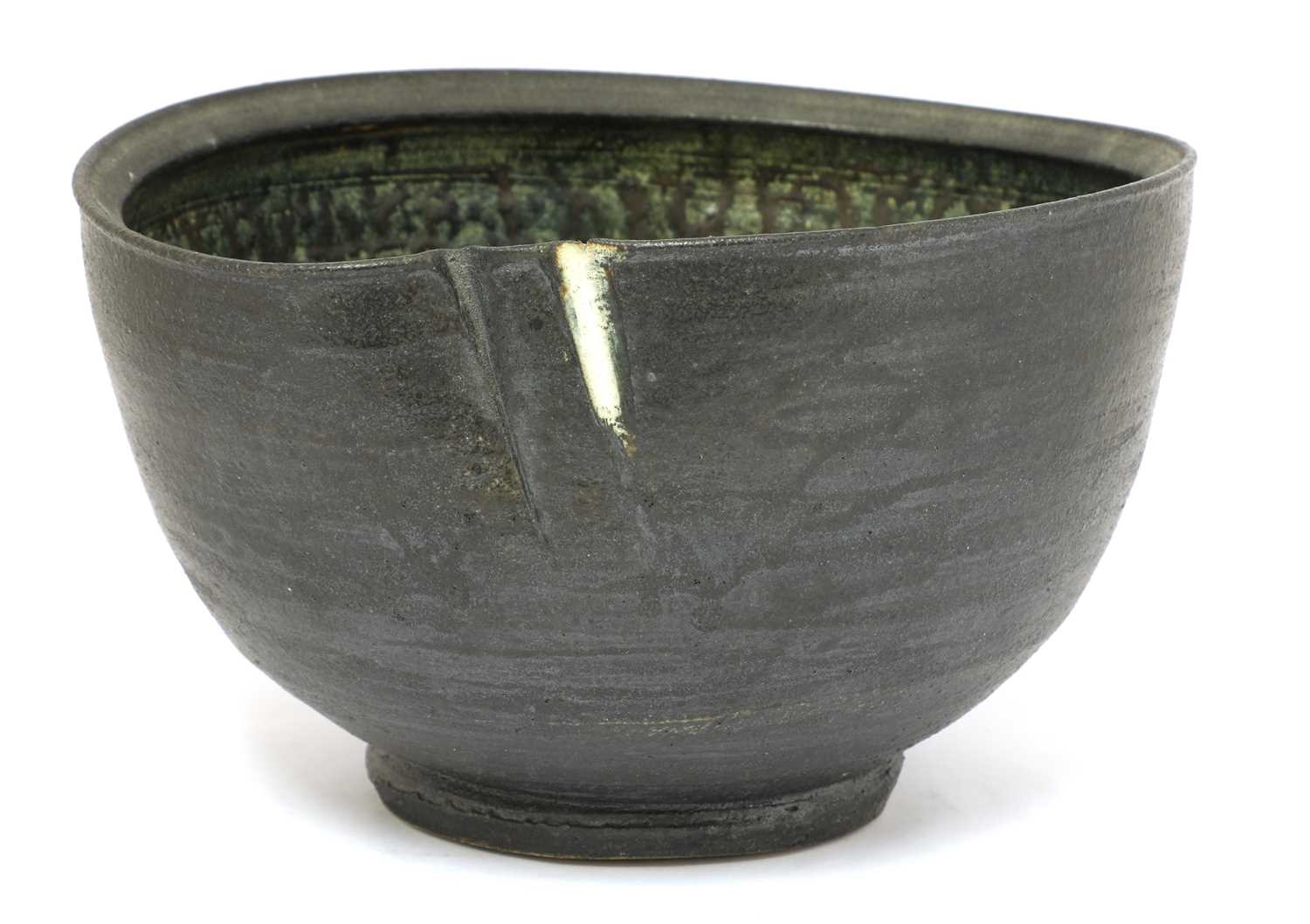 Dan Kelly | a stoneware vase with a black glaze, of compressed form ...