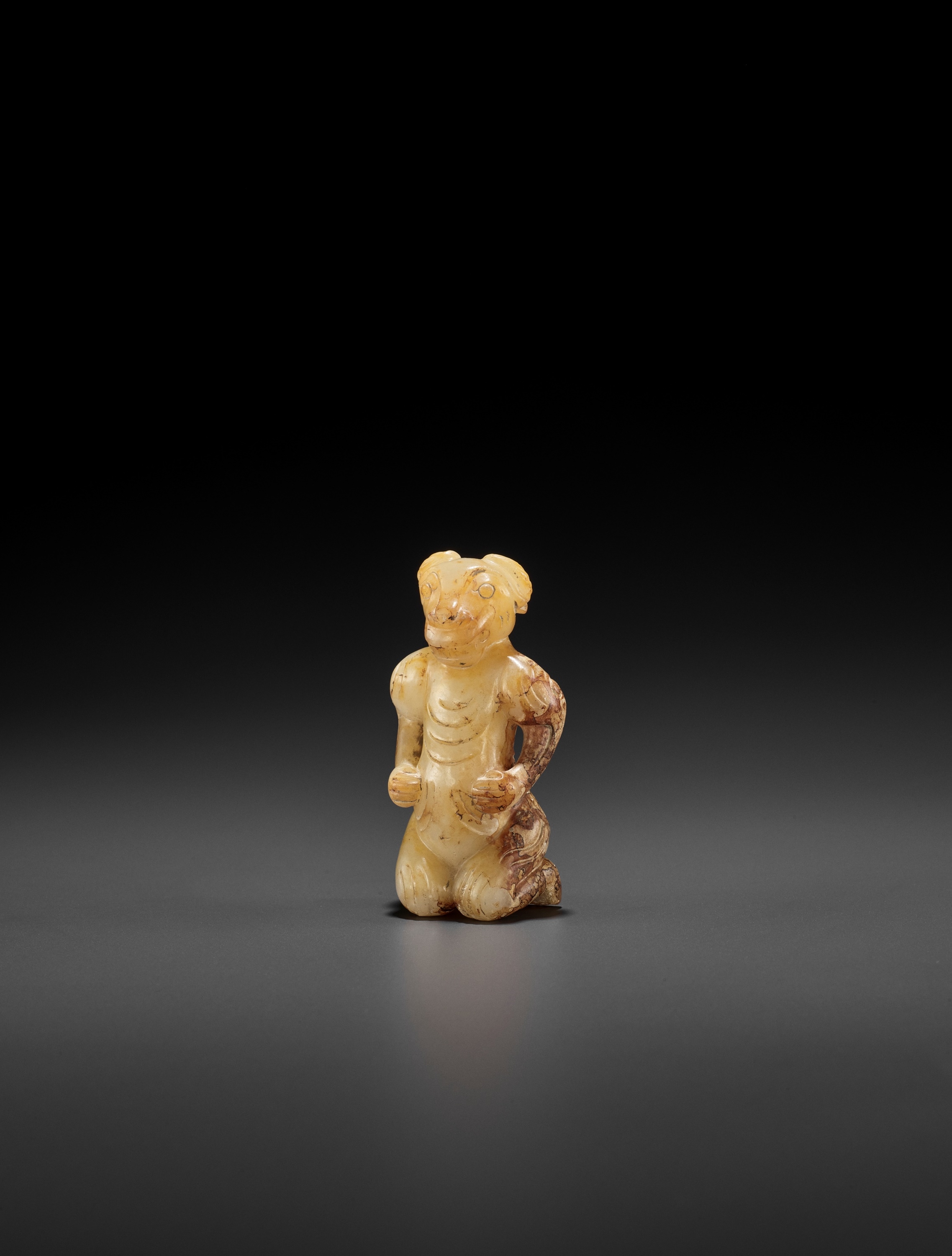 Han Dynasty | A YELLOW AND RUSSET JADE FIGURE WITH A RAM’S HEAD | MutualArt