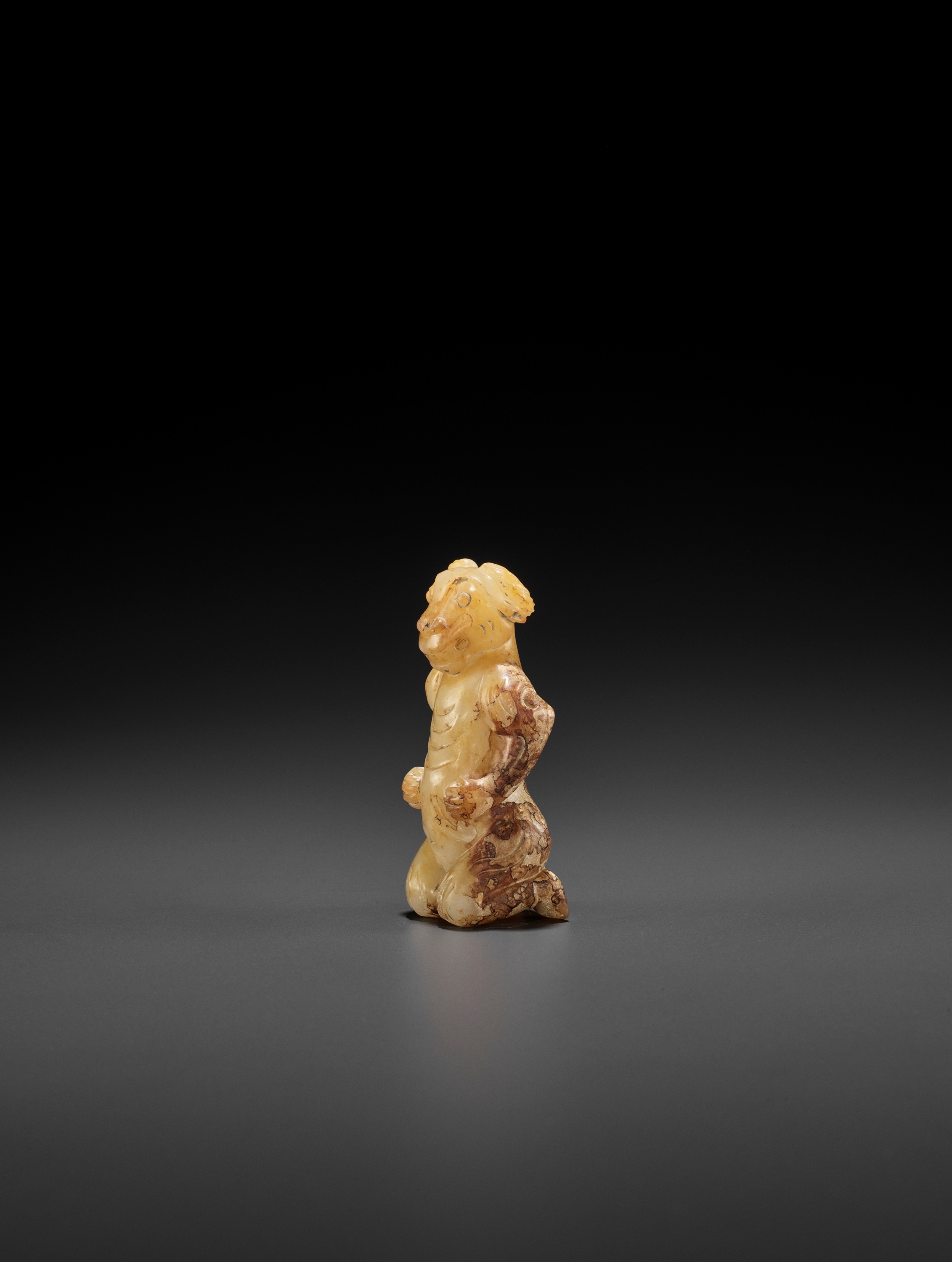 Han Dynasty | A YELLOW AND RUSSET JADE FIGURE WITH A RAM’S HEAD | MutualArt