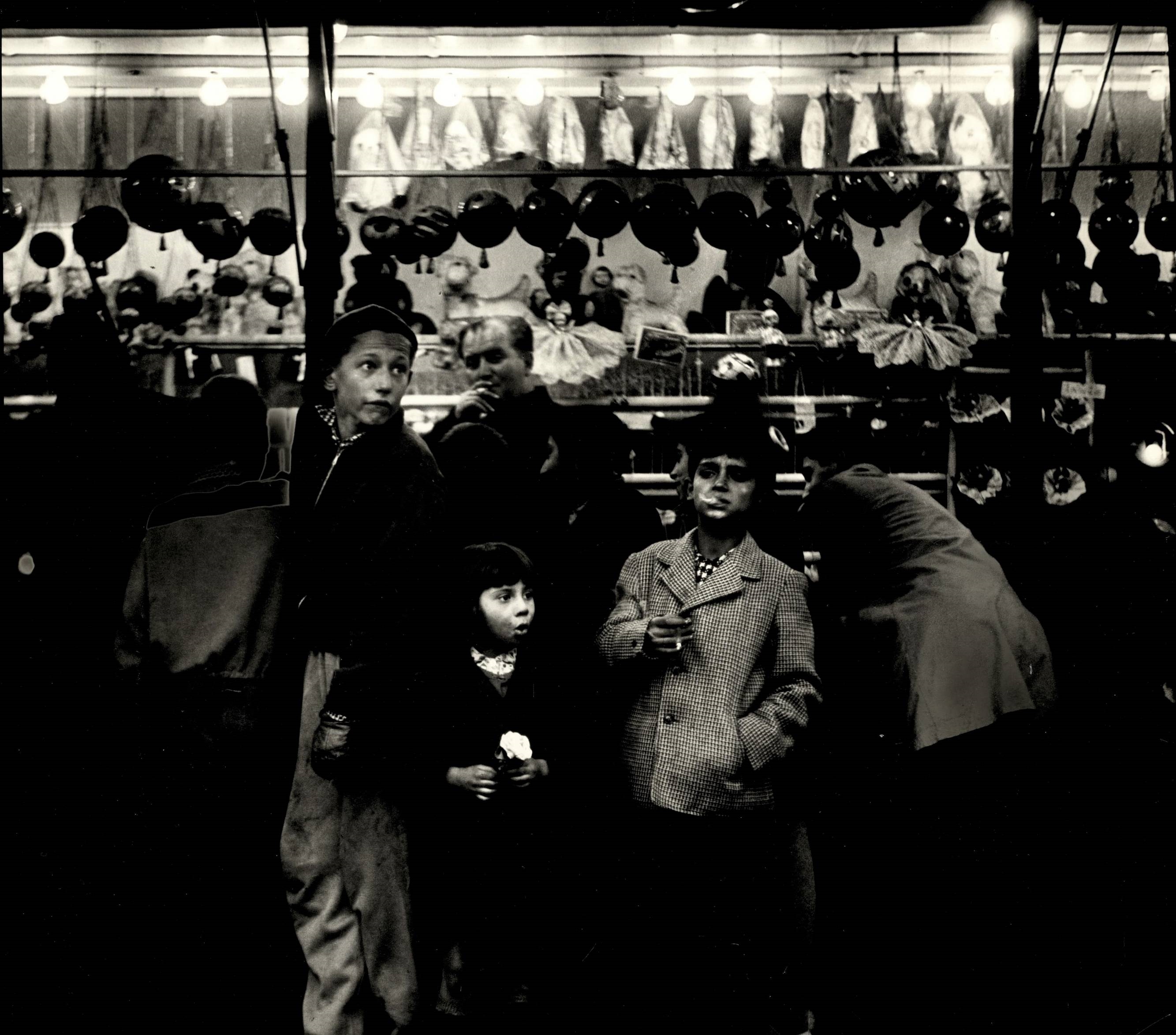 Jan Saudek | Three children in front of a fair stall | MutualArt