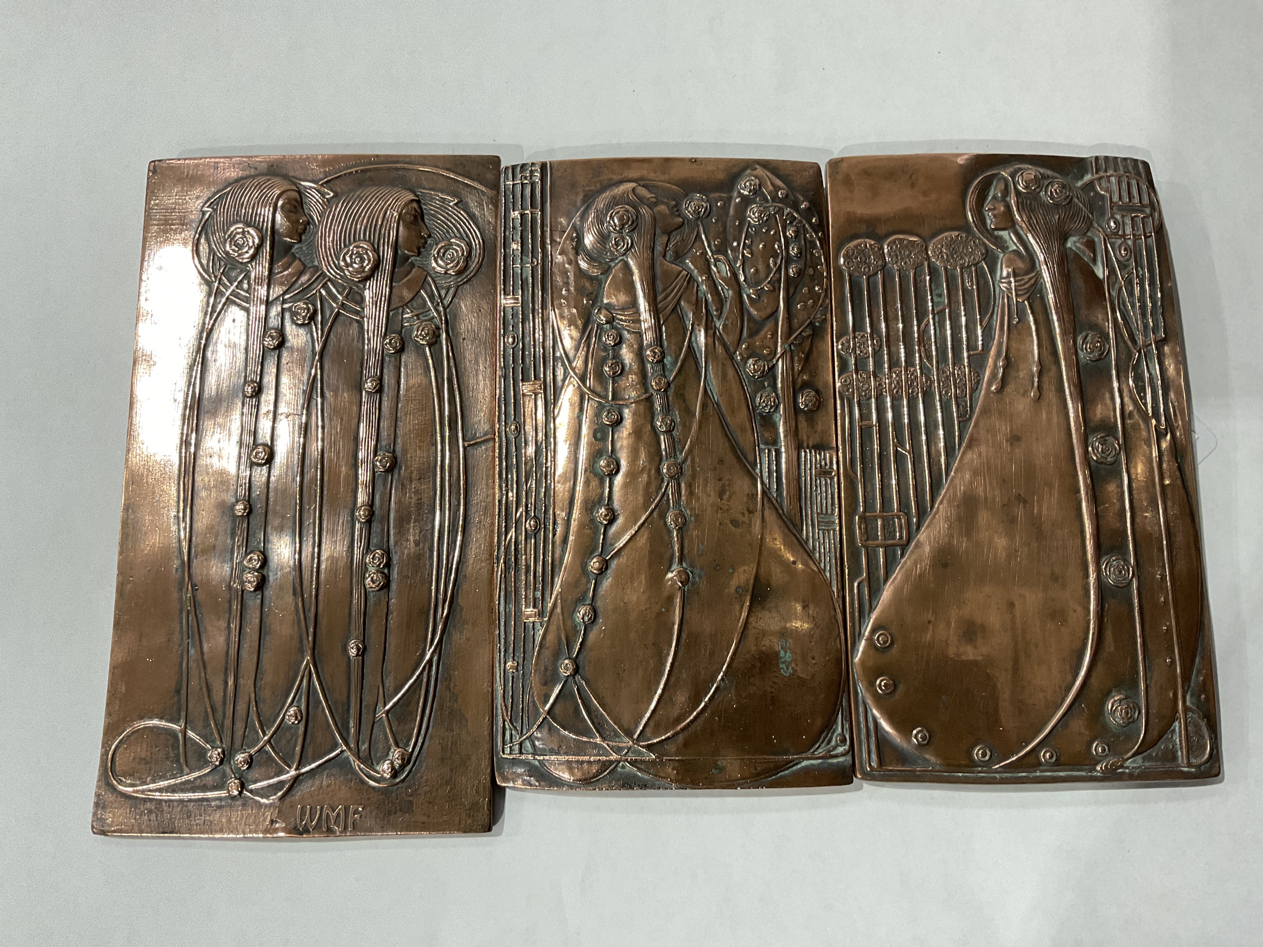 Three | Three copper Art Nouveau style wall plaques mounted on wooden ...