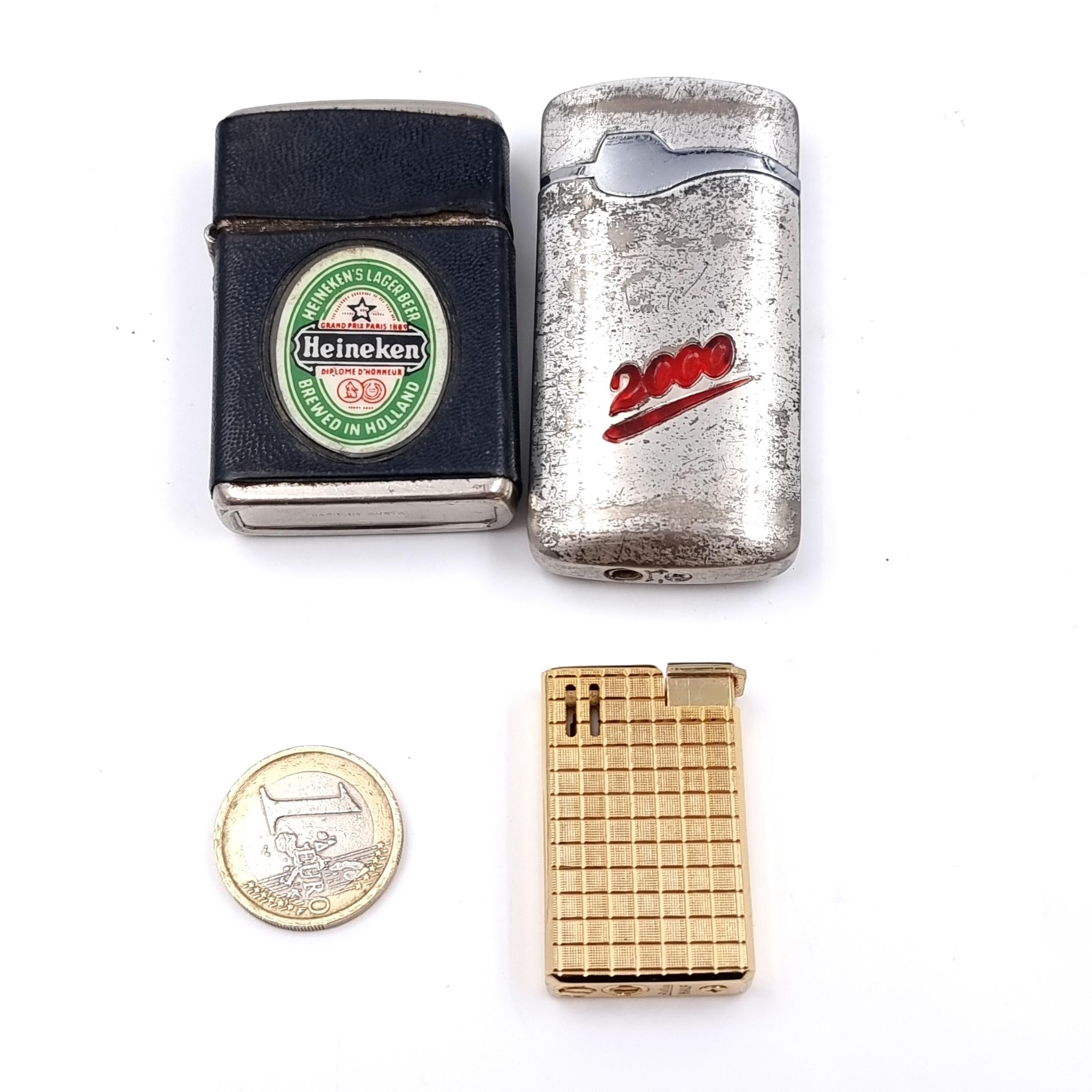 Flint | Three collectable lighters including a Heineken flint example made in Australia, A Hugo ...