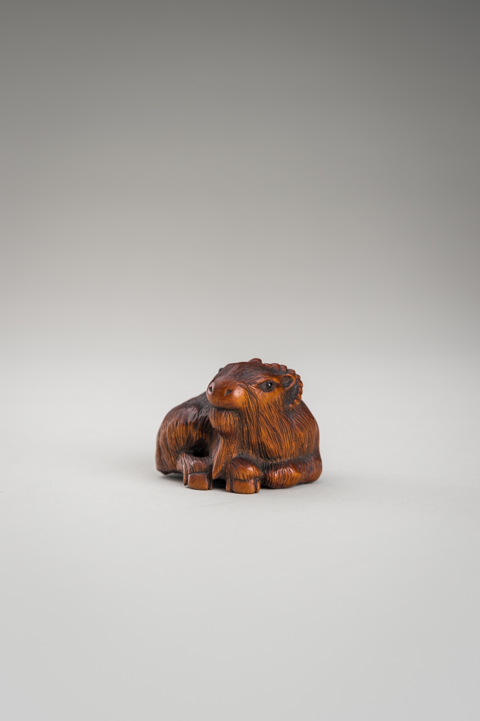 Japanese School, 20th Century | A WOOD NETSUKE OF A RECUMBENT GOAT ...