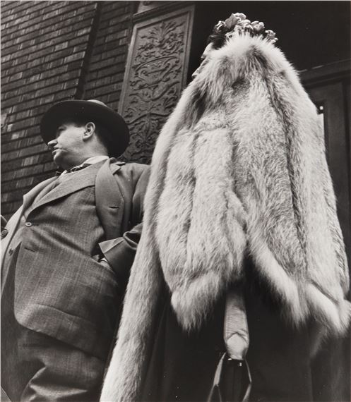 Leon Levinstein | Man in Suit, Woman in Fur Coat (1954) | MutualArt